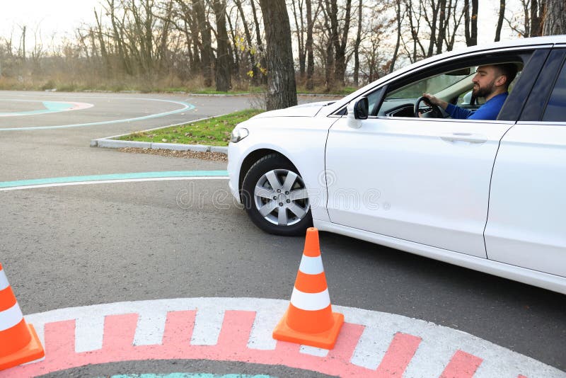 Young Man in Car on Test Track with Traffic Cones. Driving School Stock ...