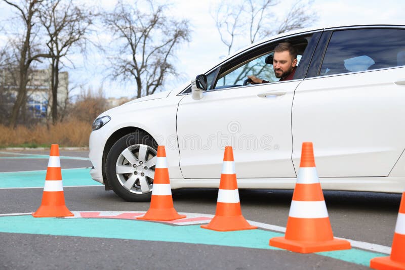 Young Man in Car on Test Track with Traffic Cones. Driving School Stock ...