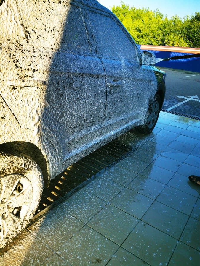 A Young Man at a Car Wash Washes the Car Under High Pressure. Selective ...