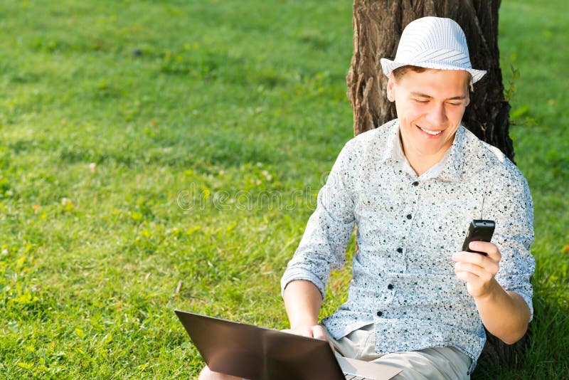 Young Man with a Cell Phone Stock Photo - Image of field, park: 33322224