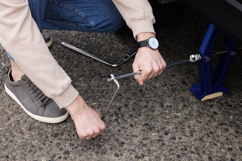 Man Changing Car Tire Near Road, Focus on Emergency Warning Triangle ...