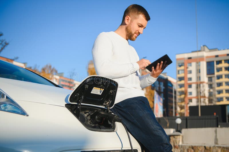 Young man charging his car stock photo. Image of battery - 237771918