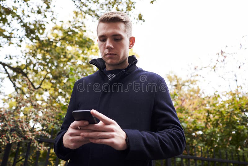 Young Man Checking Messages on Mobile Phone in Oxford Street Stock ...