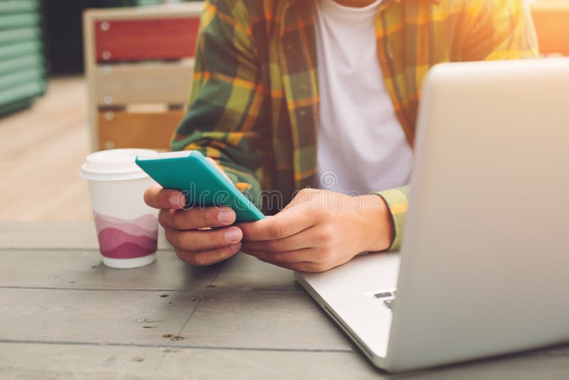 Young Man Checking Notification and Working on Computer in Street Cafe ...
