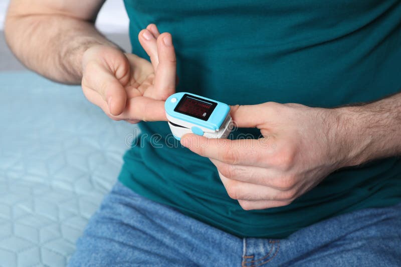 Young Man Checking Pulse with Digital Medical Device Stock Photo ...