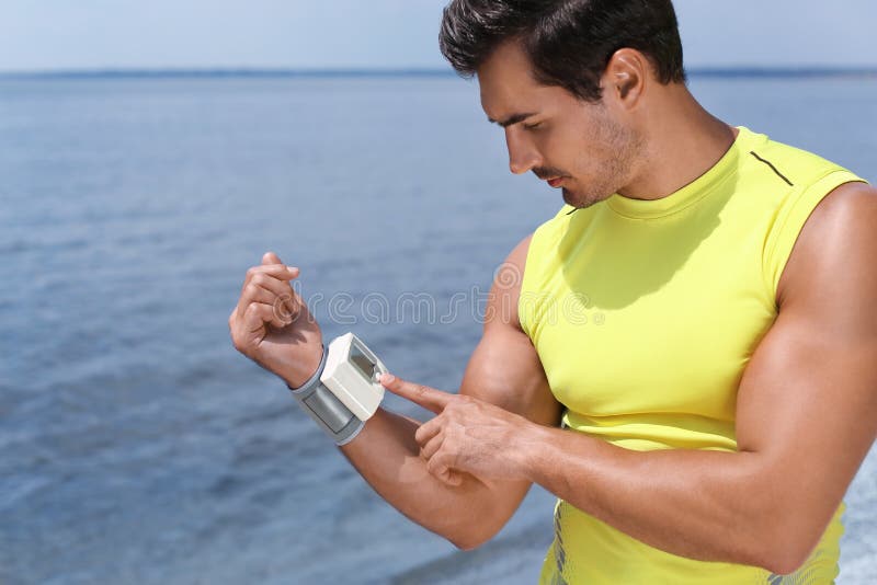 Young Man Checking Pulse with Medical Device after Training Stock Photo ...