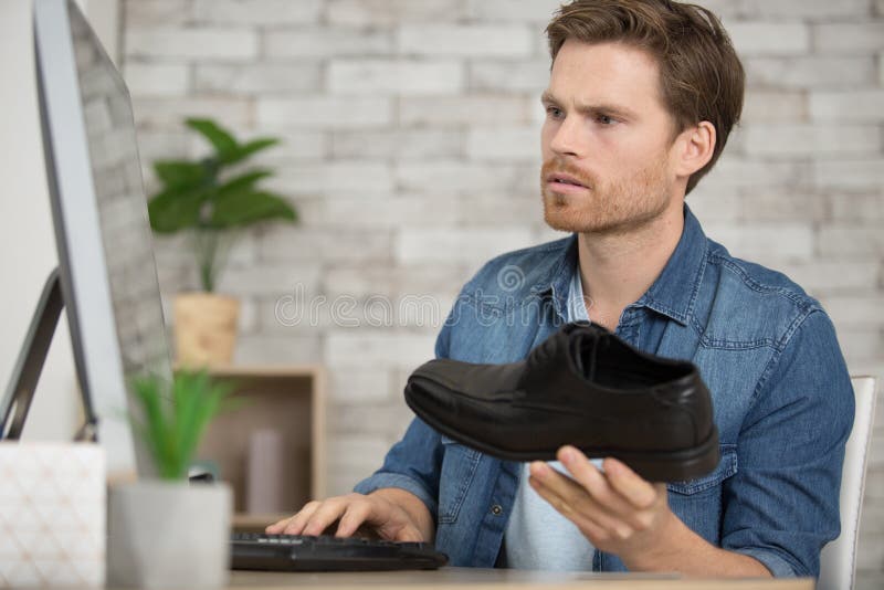 Young Man Checking Shoe Reference at Home Stock Photo - Image of room ...