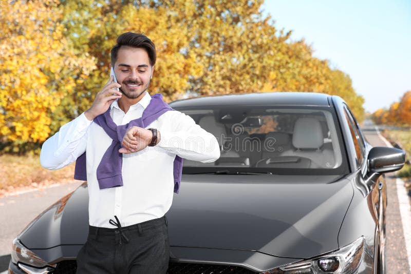 Young Man Checking Time while Talking on Phone Stock Image - Image of ...