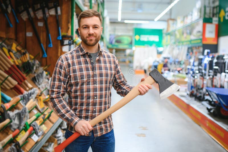 A Young Man Chooses Axe in the Hardware Store Stock Photo - Image of ...