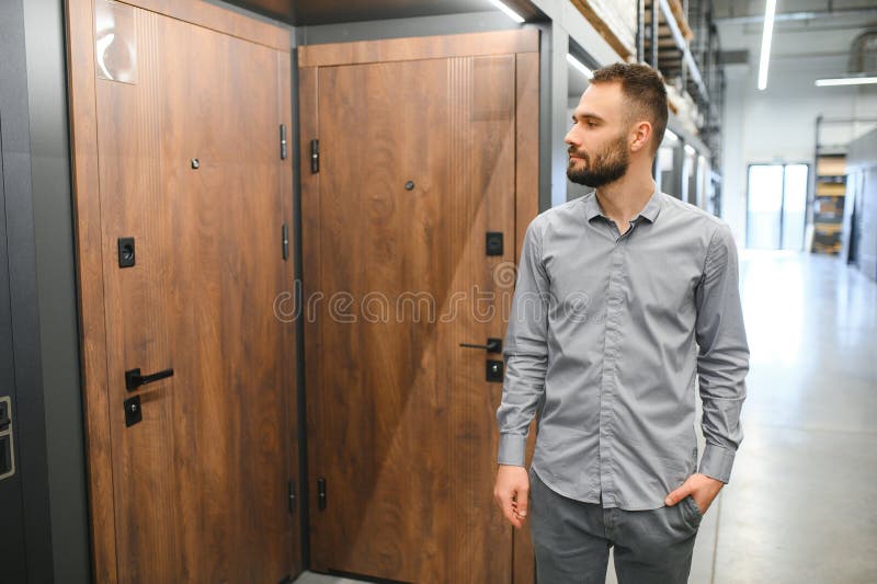 A Young Man Chooses Metal Front Door in the Hardware Store Stock Image ...