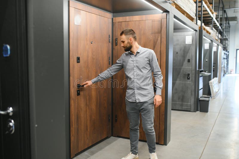 A Young Man Chooses Metal Front Door in the Hardware Store Stock Photo ...