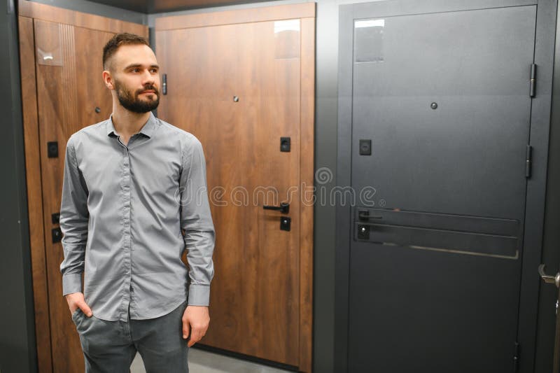A Young Man Chooses Metal Front Door in the Hardware Store Stock Photo ...