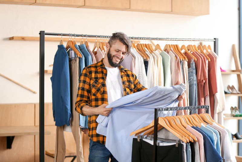 Young Man Choosing Clothes in Shop Stock Image - Image of boutique ...