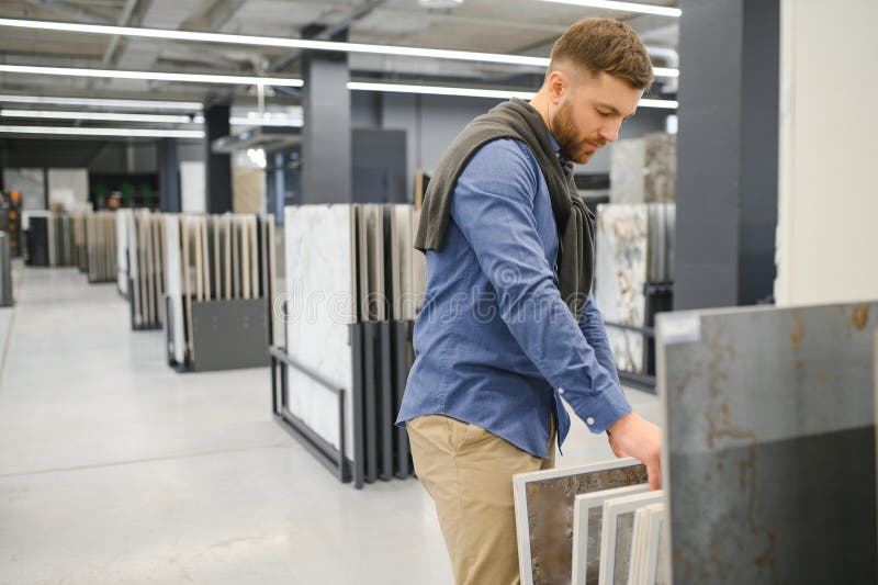 Young Man Choosing Tiles at Building Market Stock Photo - Image of ...