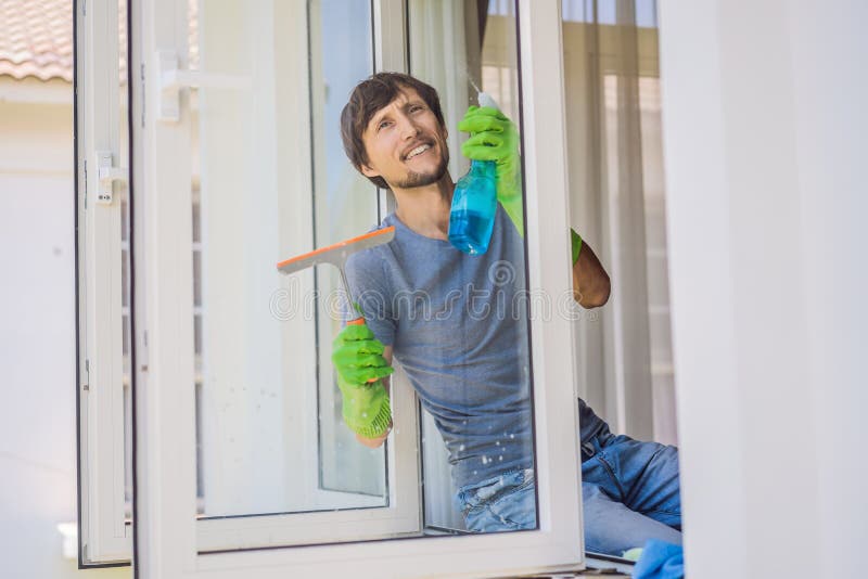 A Young Man Cleaning the Window with a Window Cleaner Stock Image ...