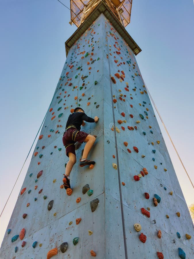 A Young Man Climbs the Wall for Climbing in Special Equipment. View ...