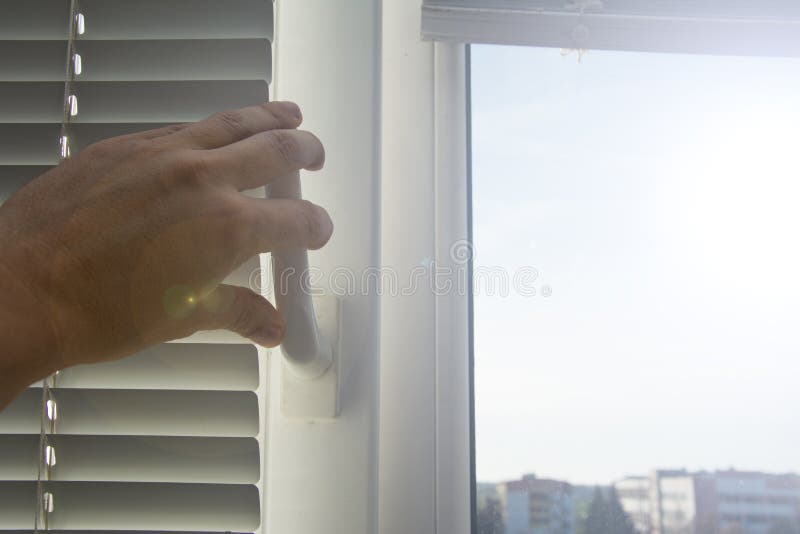 A Young Man Closes or Opens Window with Lowered Horizontal White ...