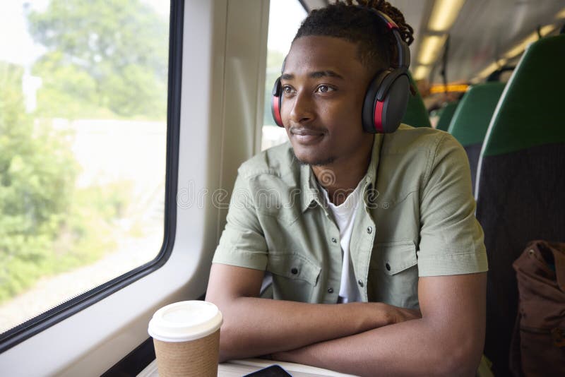 Young Man Commuting To Work Sitting on Train Wearing Wireless ...