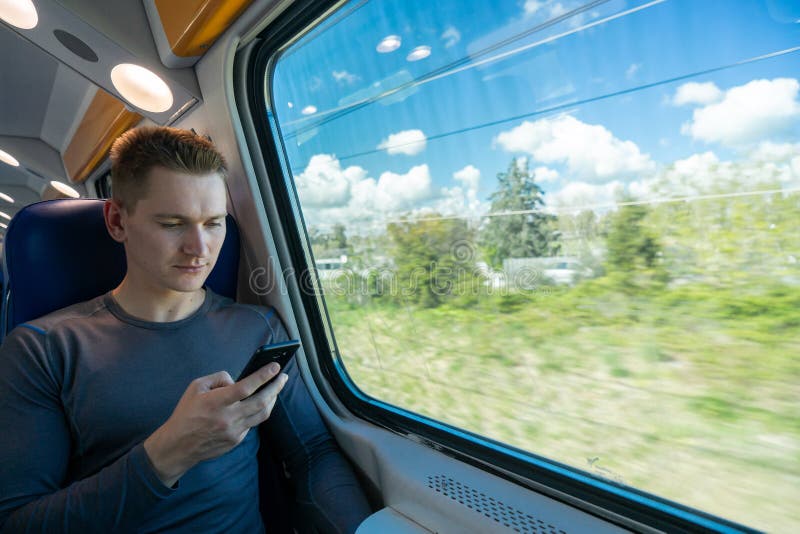 Young Man Commuting on Train Using Mobile Phone Stock Image - Image of ...
