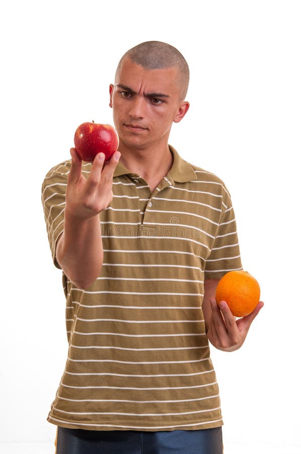 Young Man Comparing Apple To Orange Stock Photo - Image of people ...