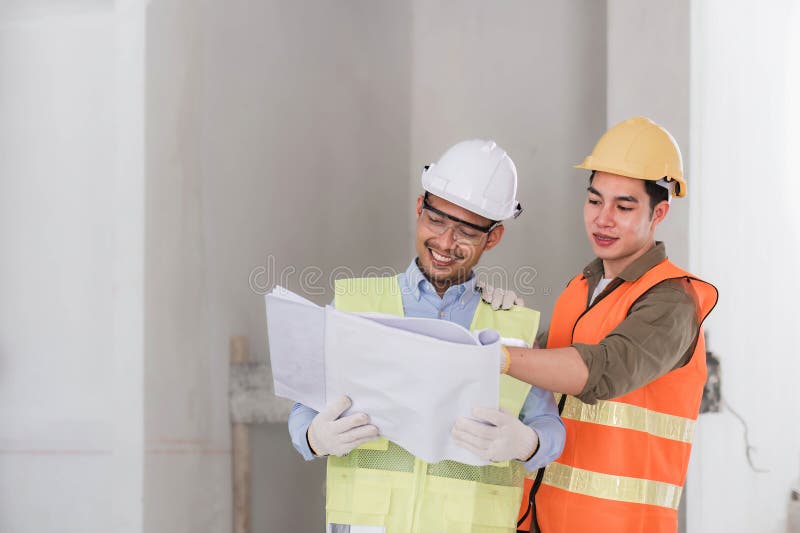 Young Man Construction Team Engineer in Vest and Hat Working with ...
