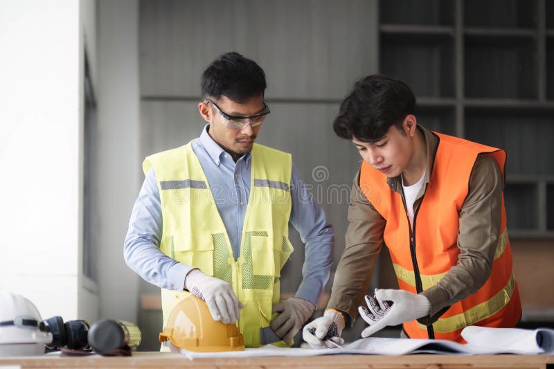 Young Man Construction Team Engineer in Vest and Hat Working with ...