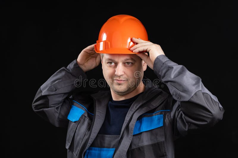 A Young Man Construction Worker in a Safety Helmet and Work Uniform on ...