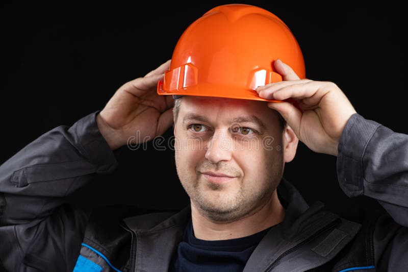 A Young Man Construction Worker in a Safety Helmet and Work Uniform on ...