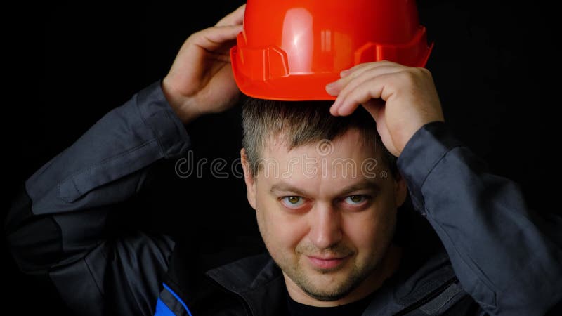 A Young Man Construction Worker in a Safety Helmet and Work Uniform on ...