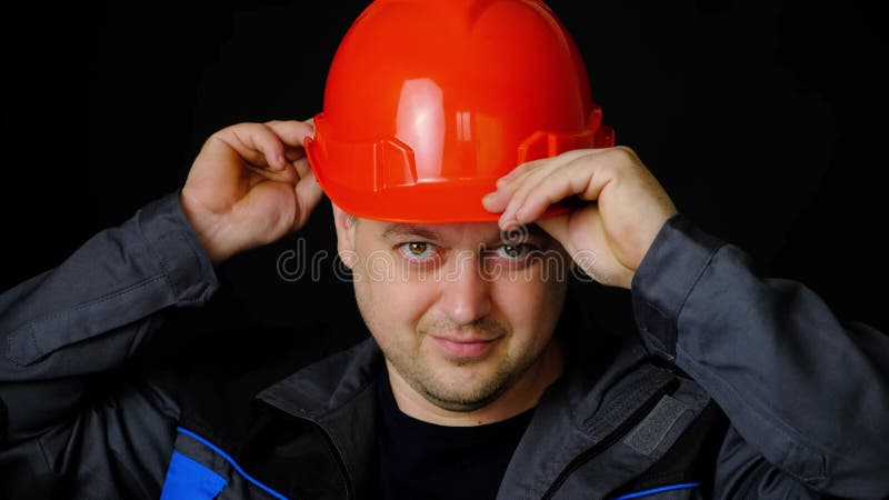 A Young Man Construction Worker in a Safety Helmet and Work Uniform on ...