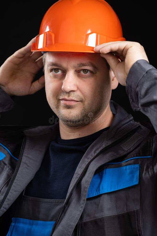 A Young Man Construction Worker in a Safety Helmet and Work Uniform on ...