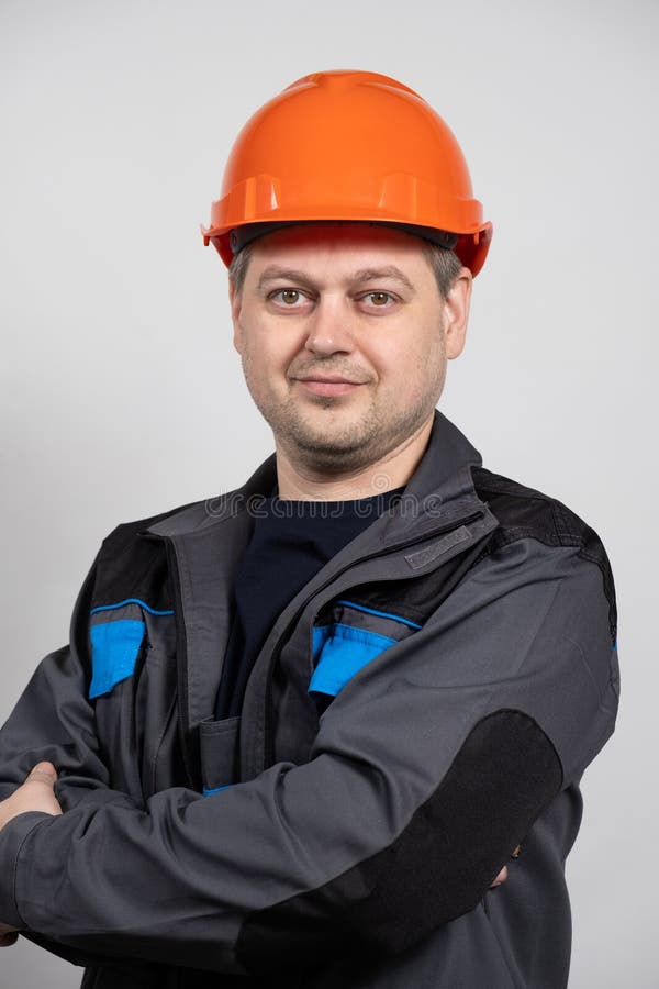 A Young Man Construction Worker in a Safety Helmet and Work Uniform on ...