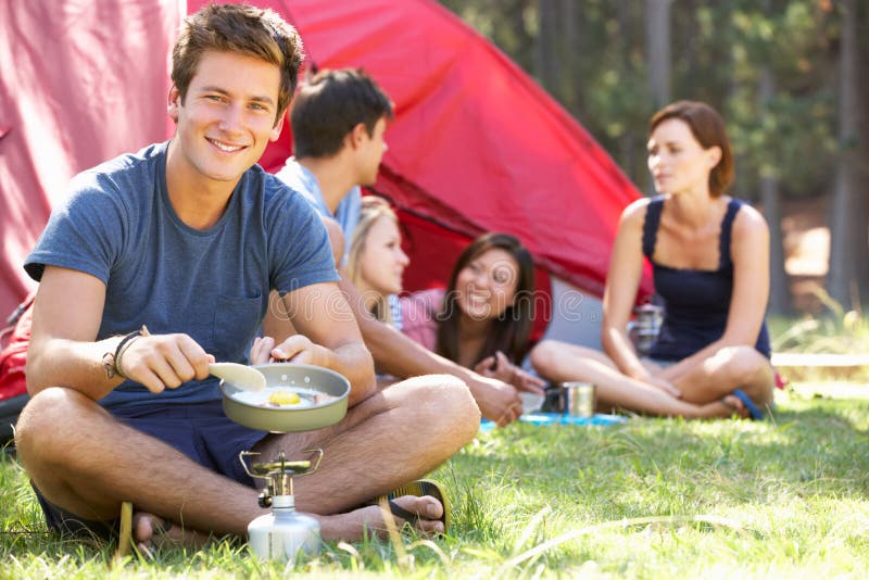 Young Man Cooking Breakfast for Friends on Camping Holiday Stock Image ...