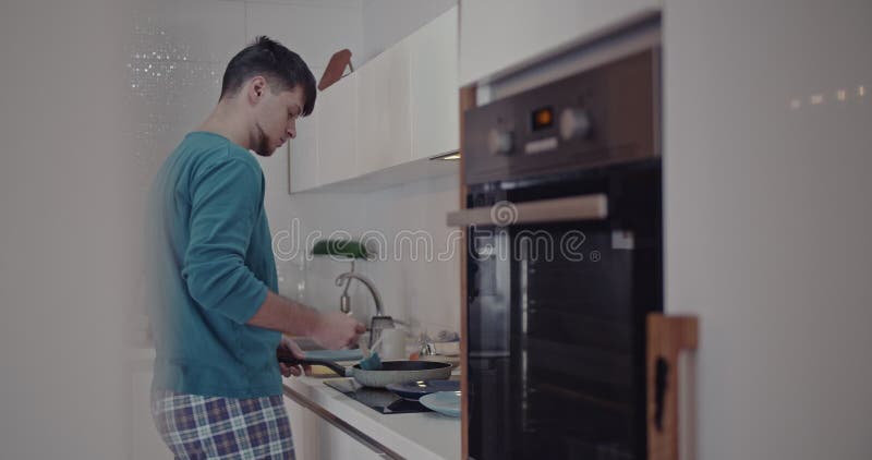 Young Man Cooking Breakfast and Making Coffee in a Modern Kitchen Stock ...