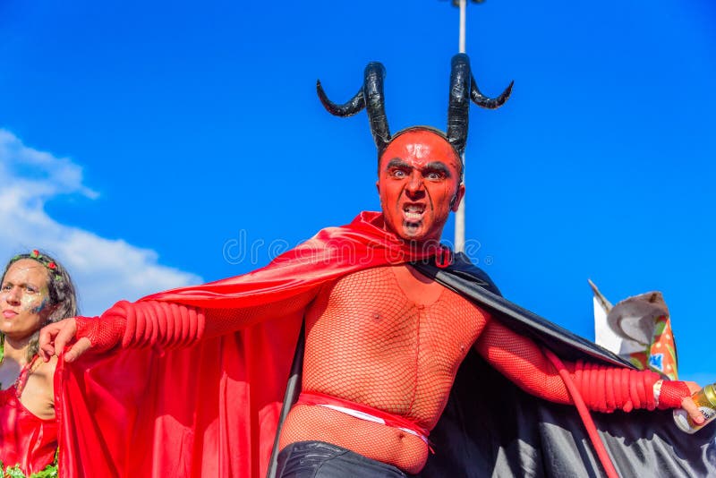 Young Man in a Costume of Devil with Red Face, Black Horns and Cloak ...