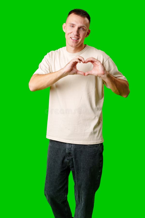 Young Man Creates Heart Shape with His Hands Against Bright Green ... Young Man Creates Heart Shape with His Hands Against Bright Green ...