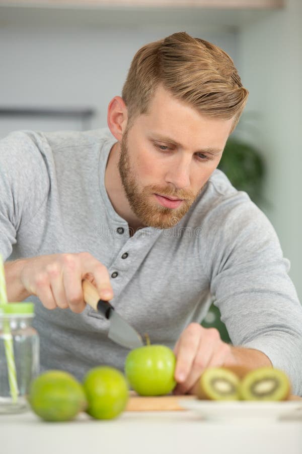 Young Man Cutting Fruit in Kitchen Stock Image - Image of health ...