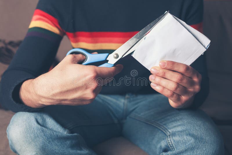 Young man cutting up paper stock image. Image of home - 46665461