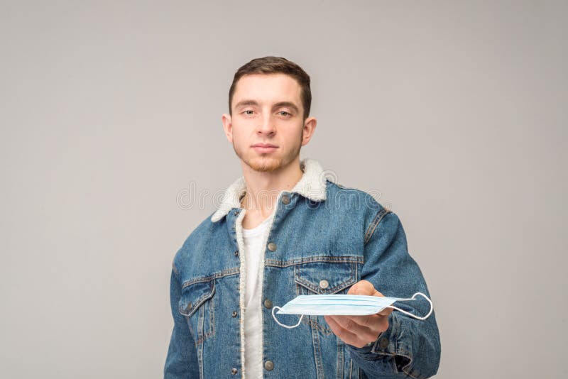 Young Man in Denim Jacket Offers Protective Face Mask. Focus on Hand ...