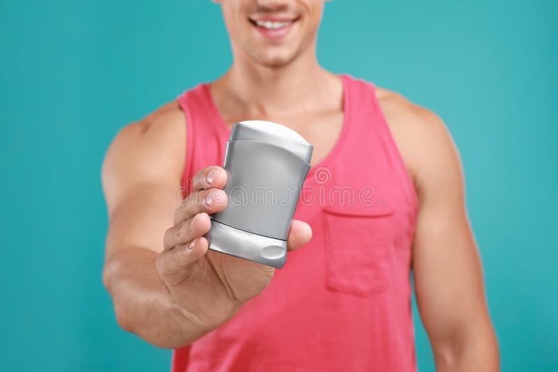 Young Man with Deodorant on Light Blue Background Stock Image - Image ...
