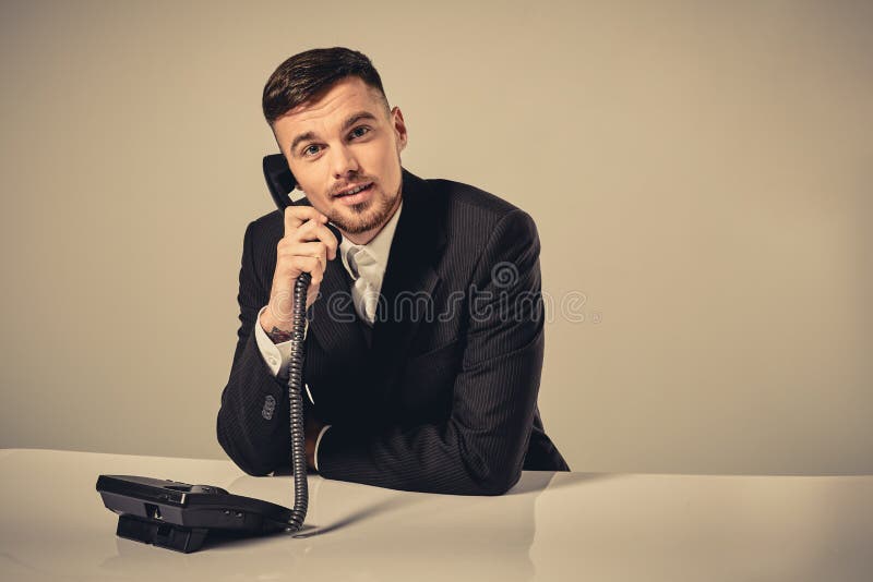 Young Man Dials the Phone Number while Sitting in the Office Stock ...