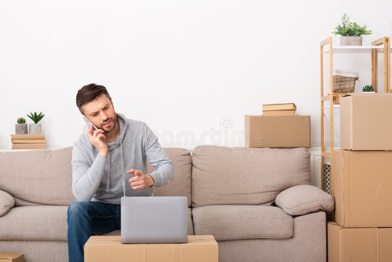 Young Man Discussing Something by Phone Indicating on Laptop Stock ...