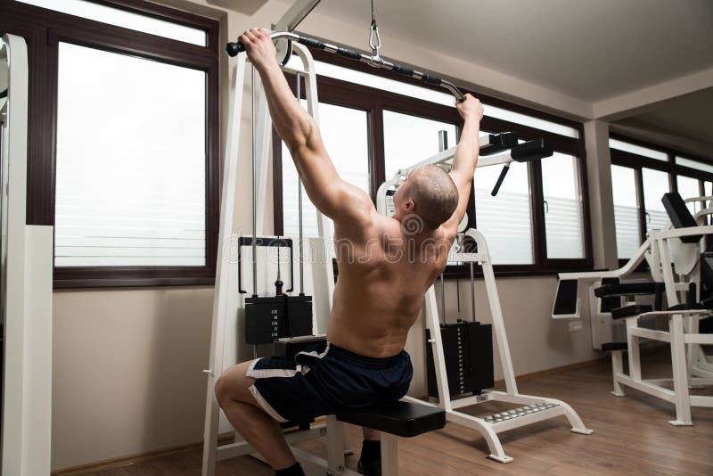 Young Man Doing Back Exercise on a Machine Stock Photo - Image of ...