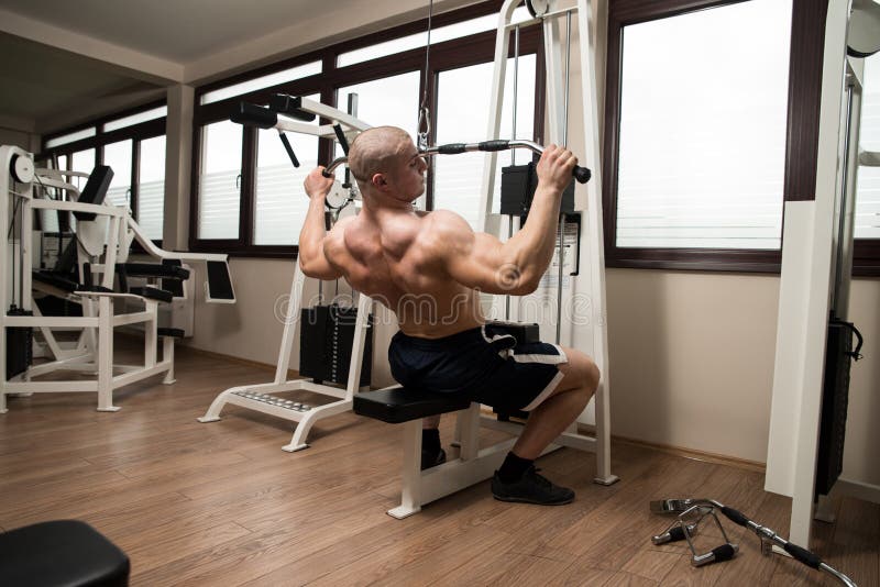 Young Man Doing Back Exercise on a Machine Stock Photo - Image of back ...