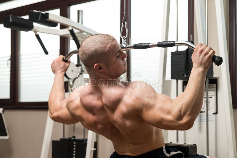 Young Man Doing Back Exercise on a Machine Stock Photo - Image of ...