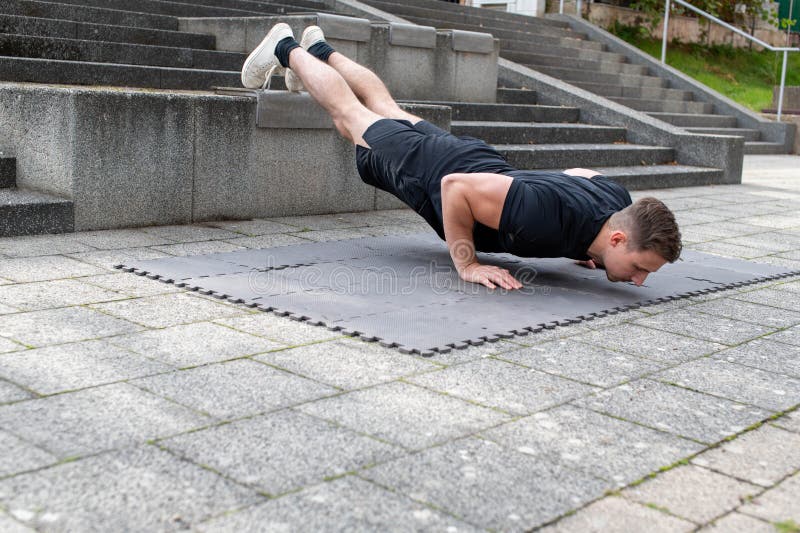 Young Man Doing a Decline Push-up or Elevated Push-up on Concrete ...