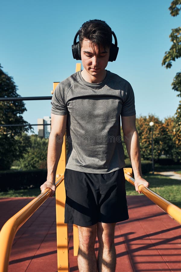 Young Man Doing Dips on Parallel Bars during His Workout in a Modern ...