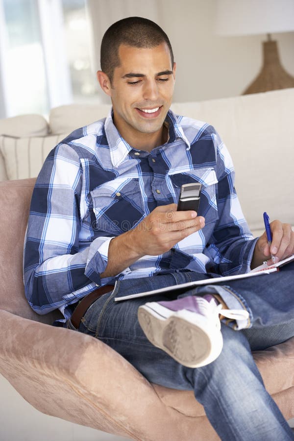 Young Man Doing Paperwork and Using Mobile Phone at Home Stock Photo ...