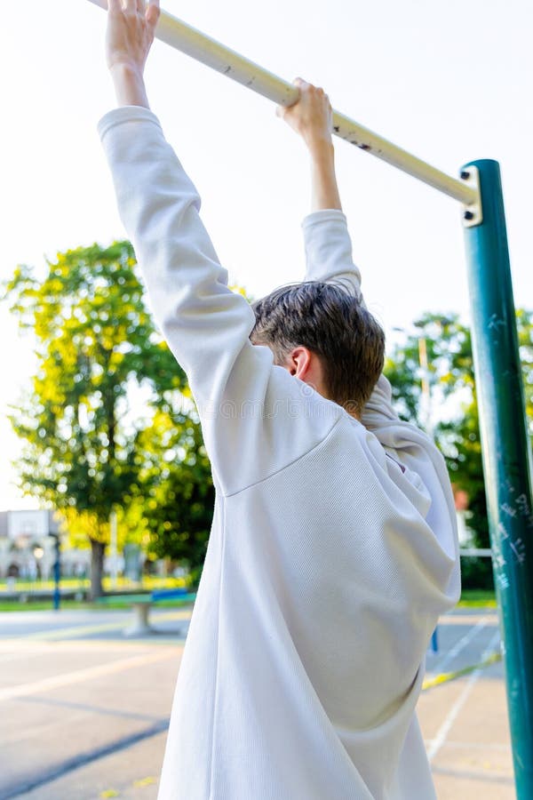 Young Man Exercising on Parallel Bars at a Park on a Sunny Day Stock ...