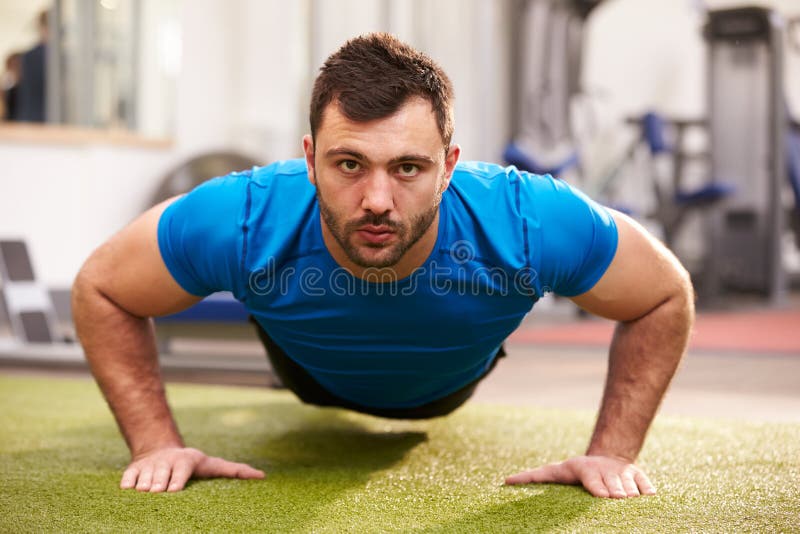 Young Man Doing Push Ups at a Gym, Looking To Camera Stock Photo ...